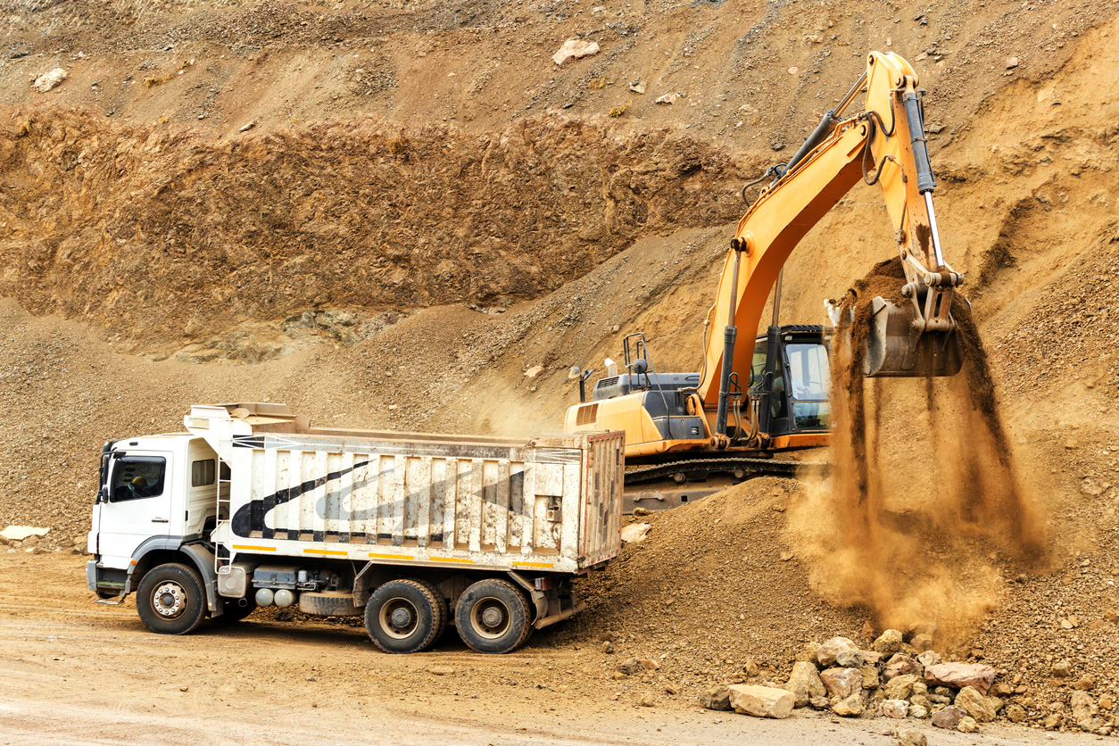 The excavator is digging and loading to a truck in the construction ...